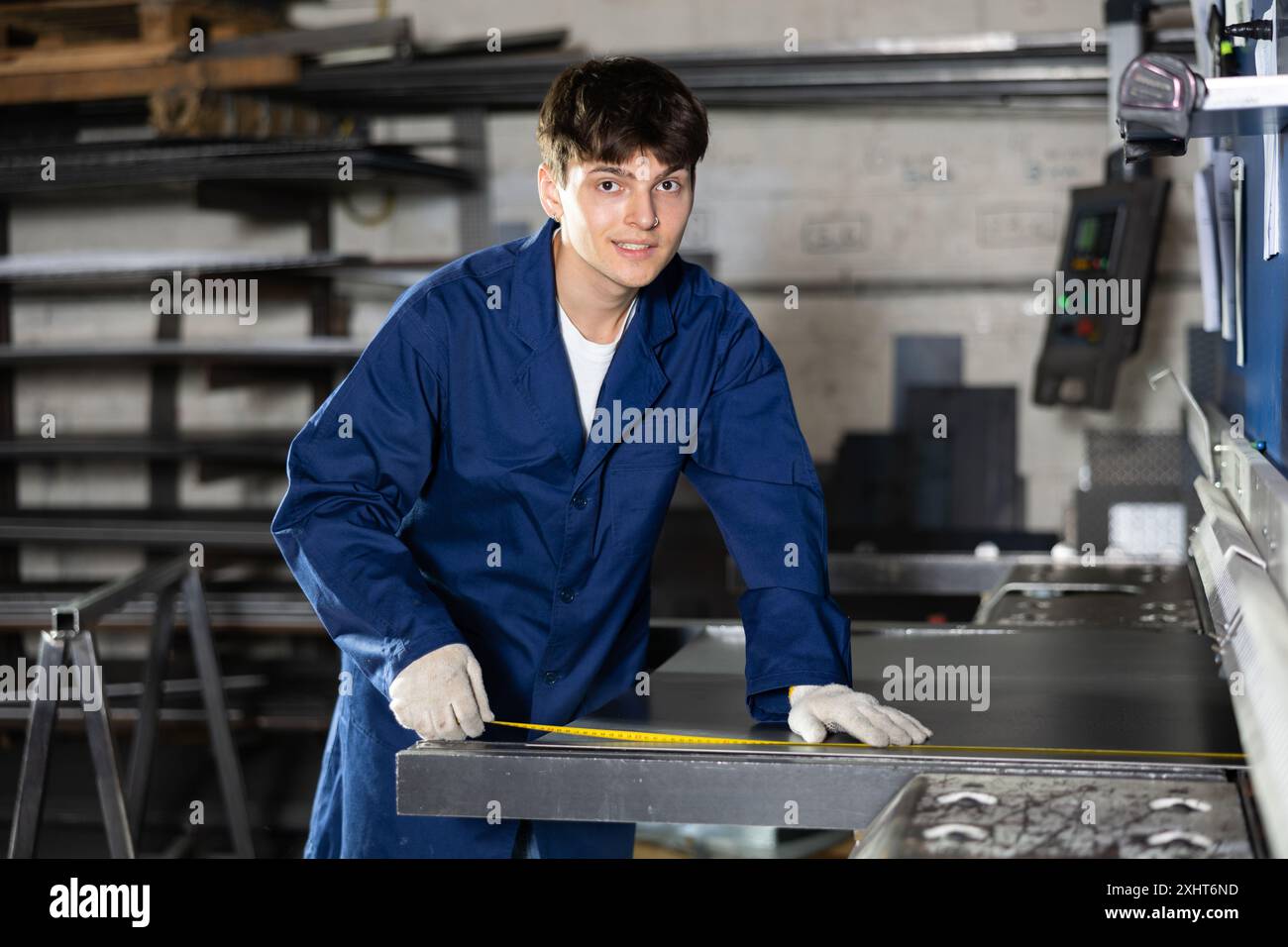 Guy measuring sheet of metal with tape measure Stock Photo - Alamy