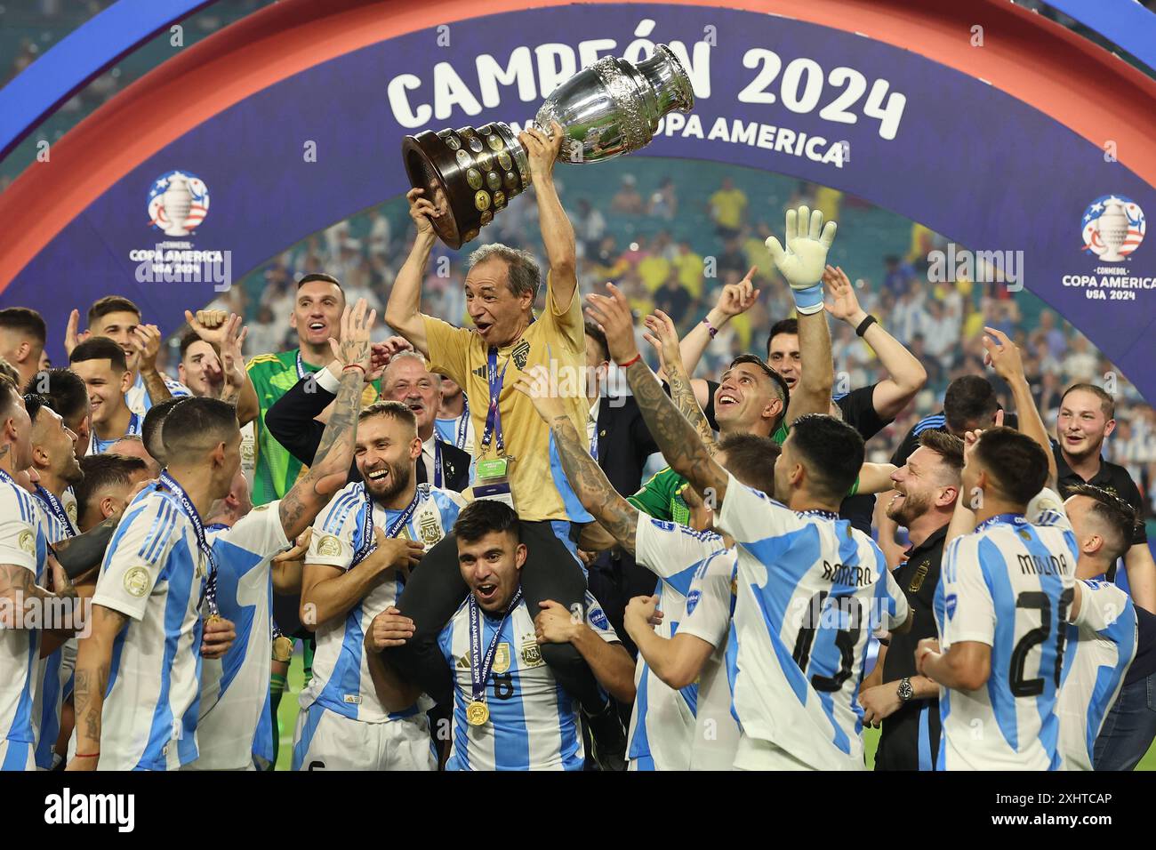 Argentinas staff member Mario Di Stefano celebrates lifts the trophy ...
