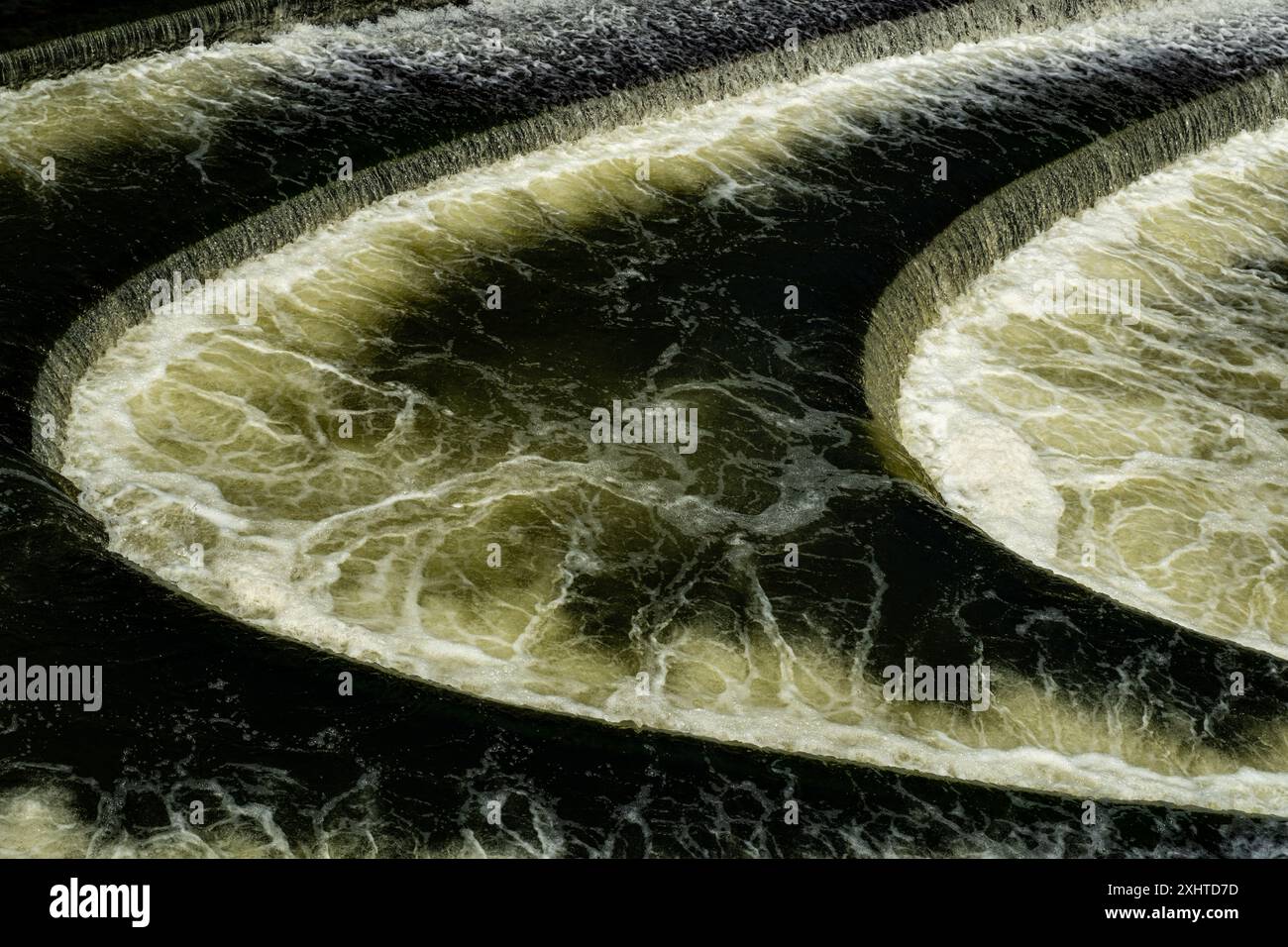 White water bubbles over the weir on the Avon River below the Pulteney ...
