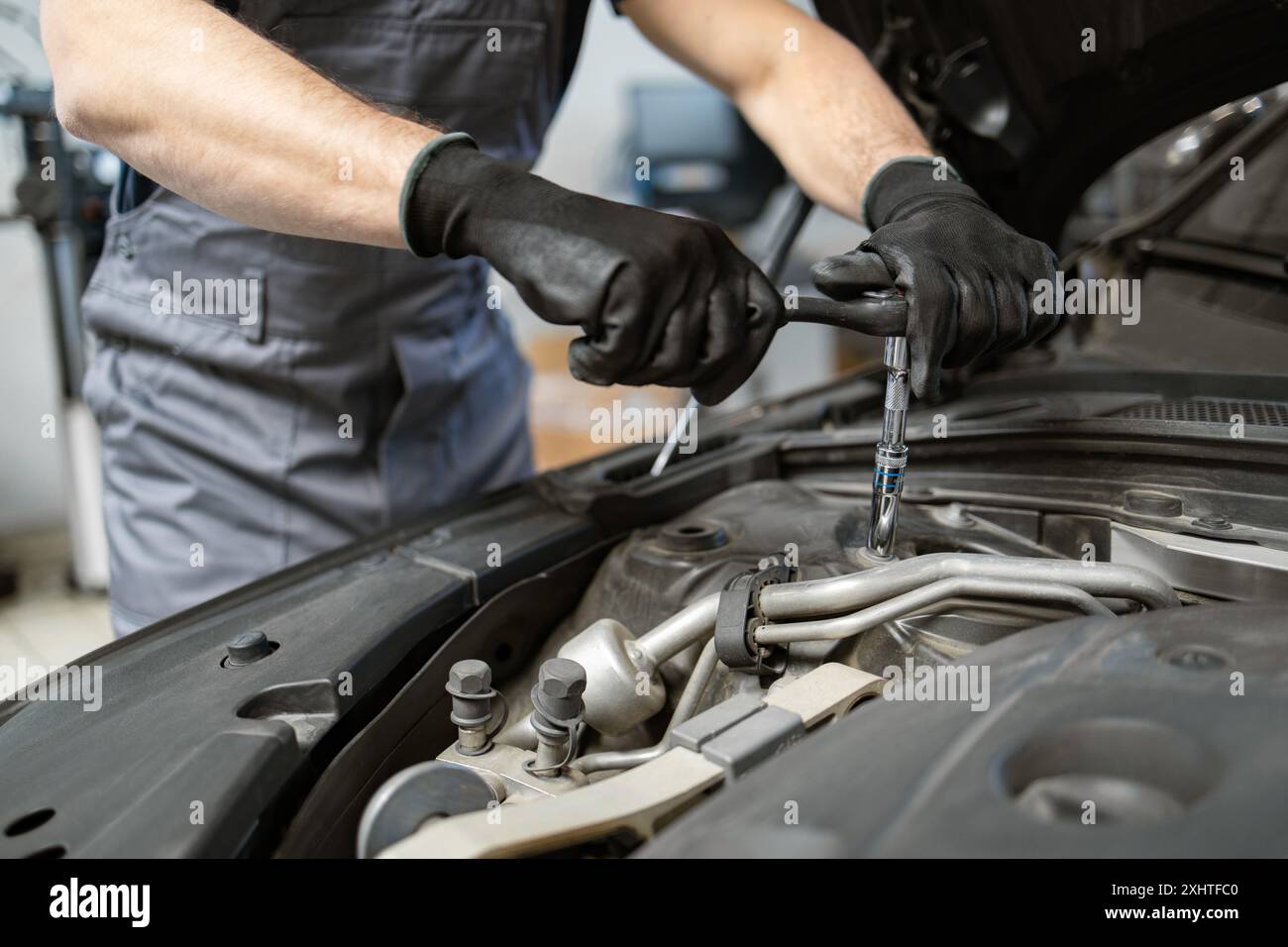 Mechanic working on car engine in auto repair shop Stock Photo - Alamy