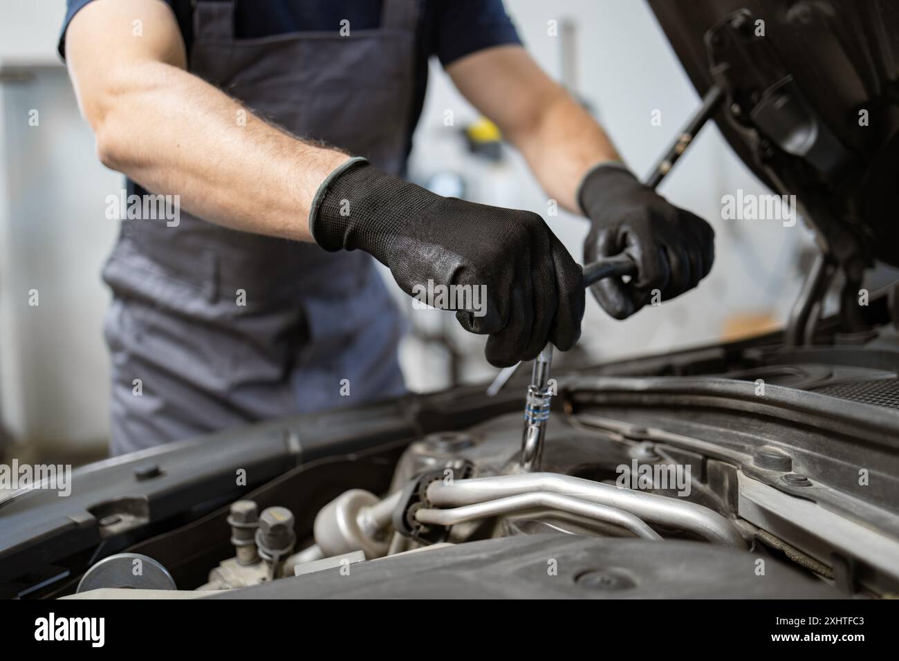 Mechanic working on car engine in service garage workshop Stock Photo ...