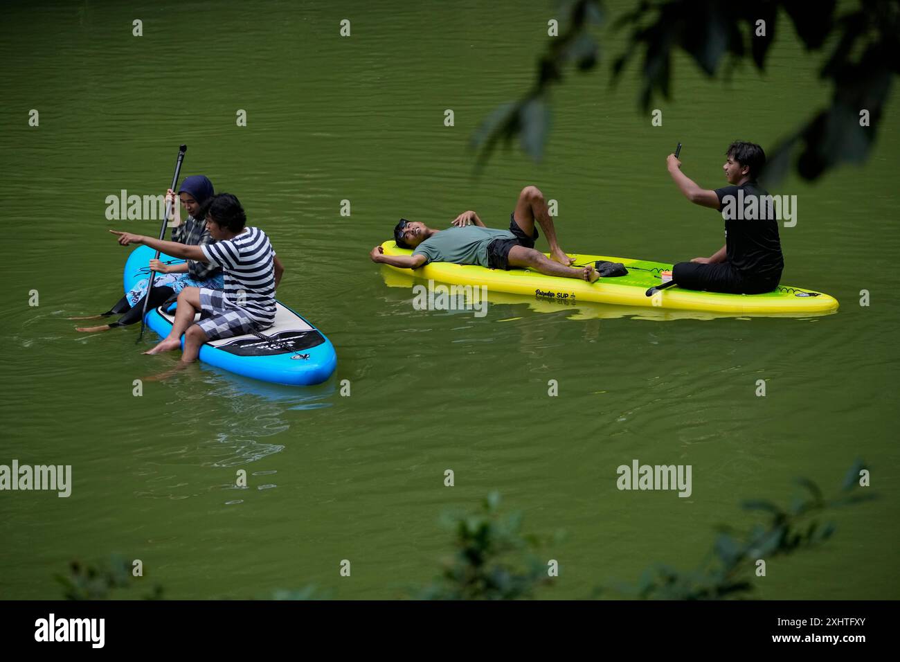 Local tourists paddle near Bokimaruru Cave in Central Halmahera, North ...