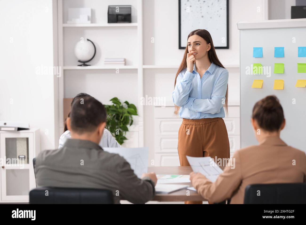 Woman feeling embarrassed during business meeting in office Stock Photo ...