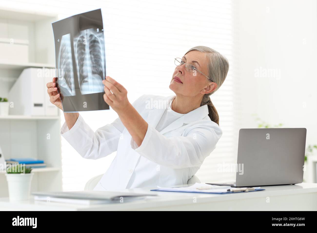 Lung disease. Doctor examining chest x-ray at table in clinic Stock ...