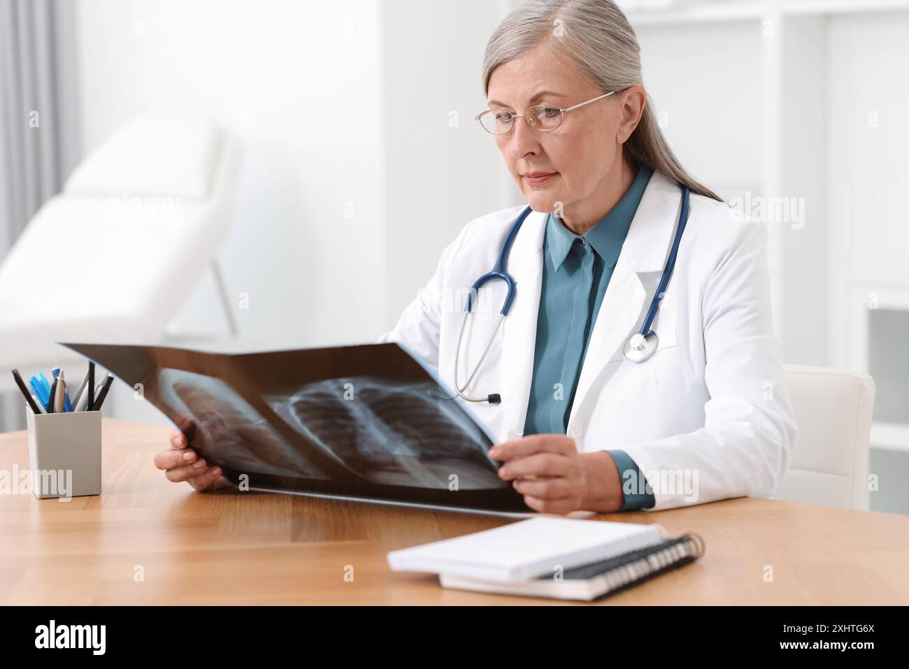 Lung disease. Doctor examining chest x-ray at table in clinic Stock ...