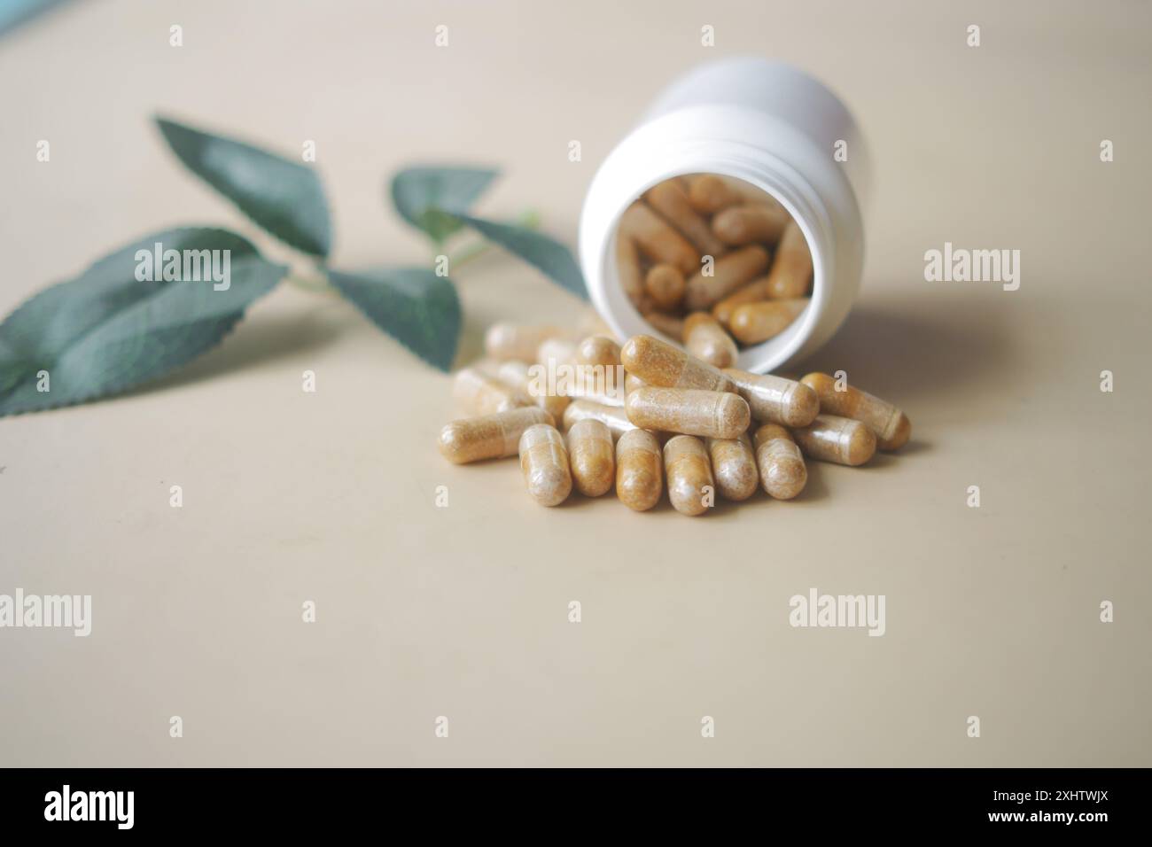 herbal medicine capsule spilled from a container Stock Photo - Alamy