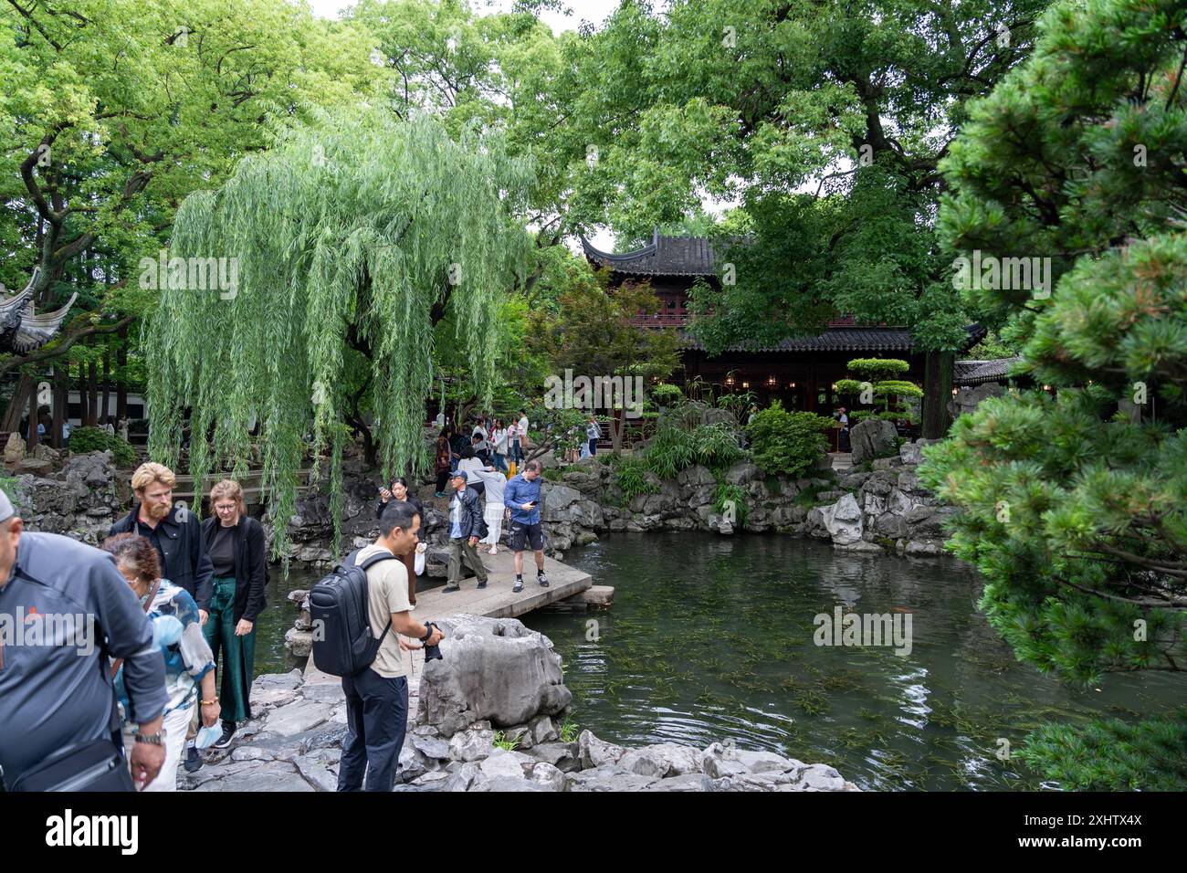 Shanghai, China - June 06, 2024 : A tranquil pond surrounded by lush ...