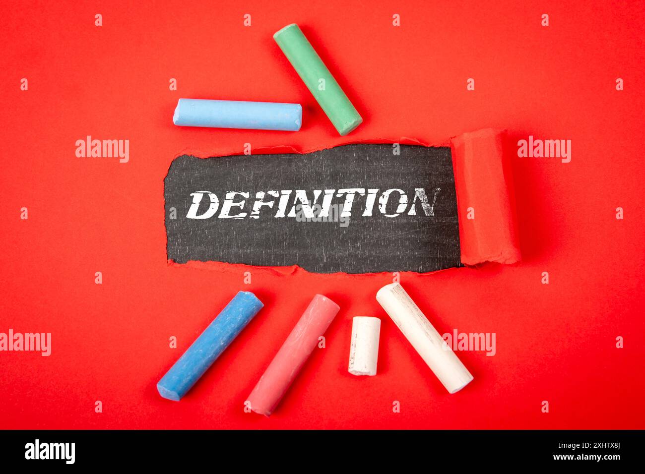 Definition. Text under torn red paper on a blackboard Stock Photo - Alamy