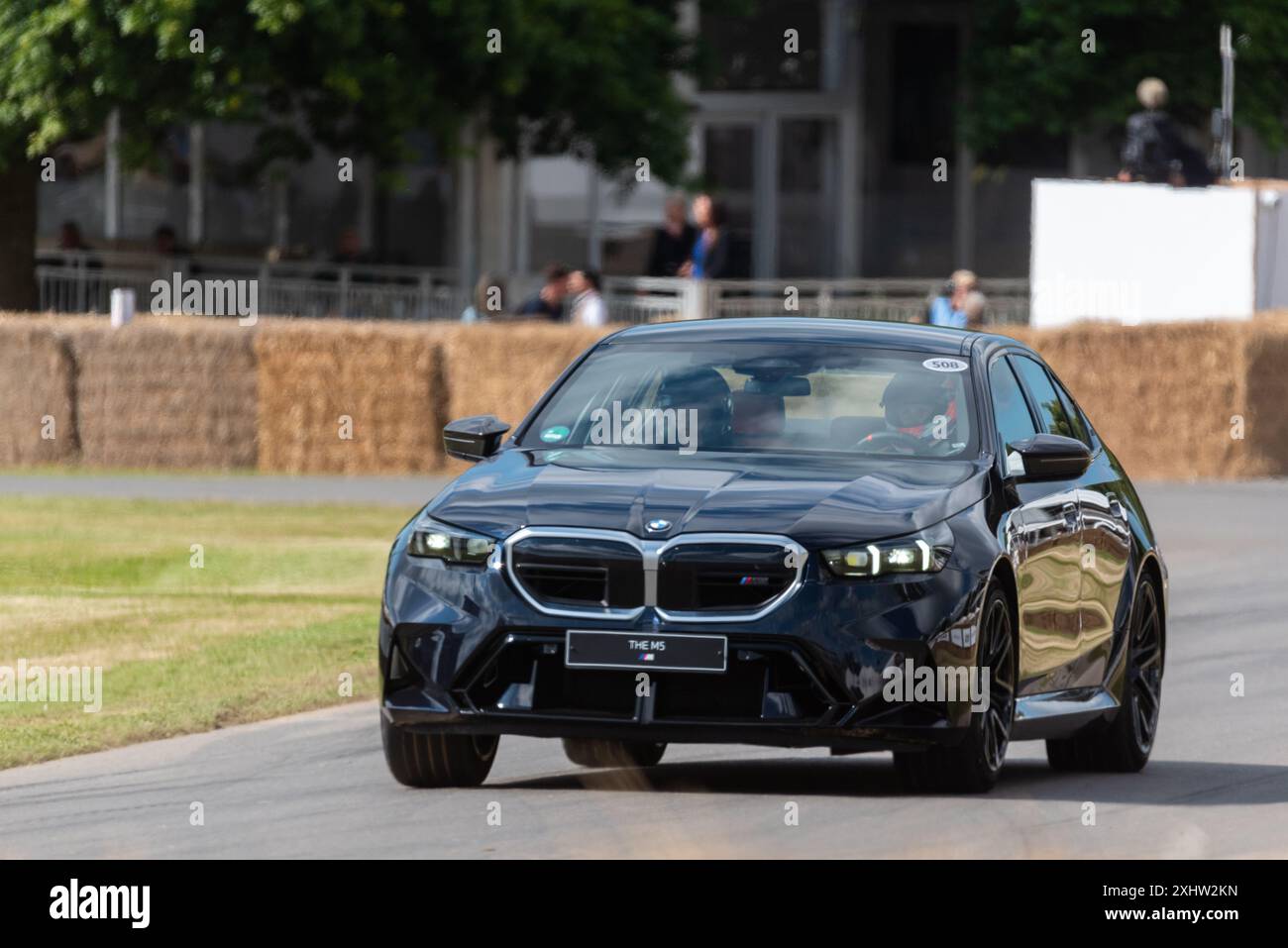 2024 BMW M5 executive sports car driving up the hill climb track at the ...