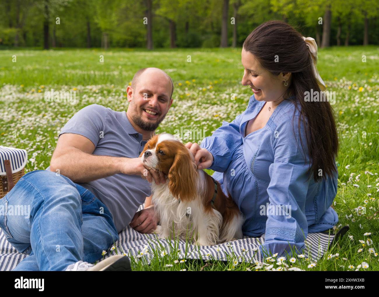 Happy pregnant couple spends time together on a picnic outdoors with a ...