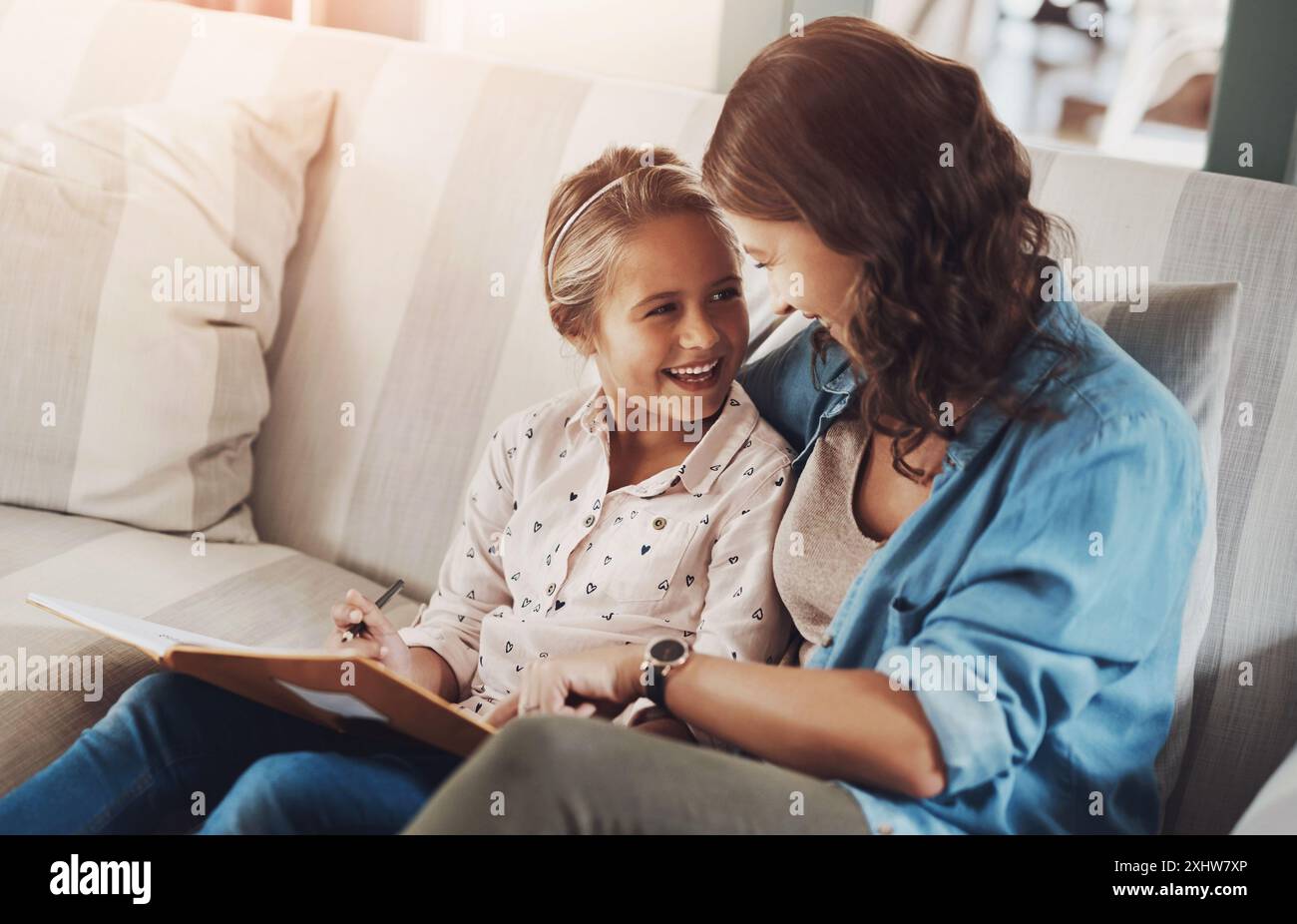Mother, girl and book on sofa for writing, learning and happy with ...