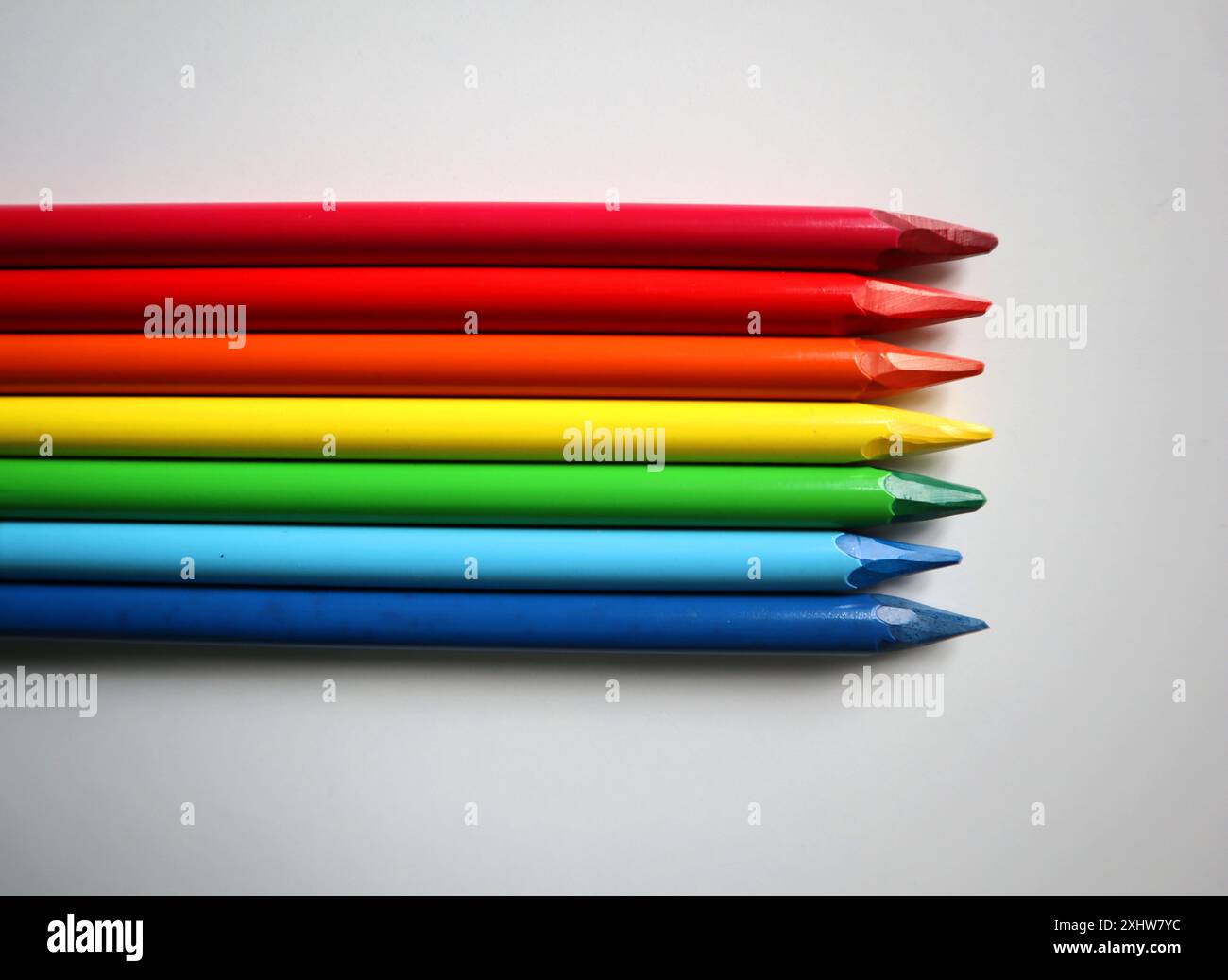 Photo of colored pencils arranged in the colors of the rainbow on white ...
