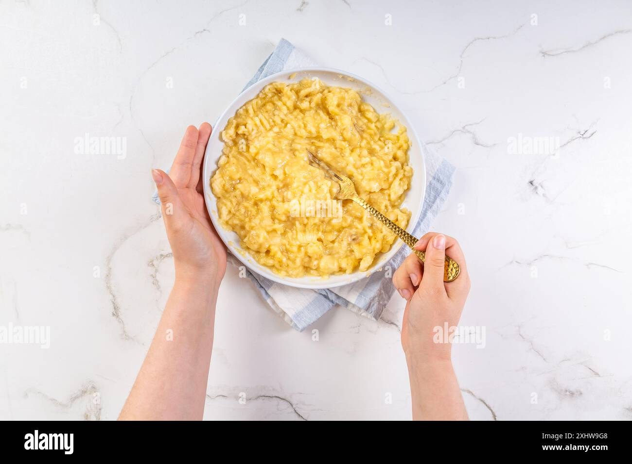 Mashing overhyped banana with fork, preparing banana cake Stock Photo ...