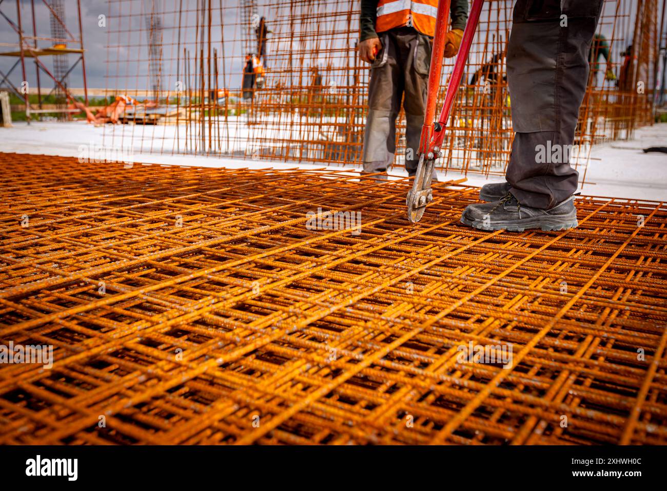Worker is standing on pile of rusty rectangle steel, reinforcement for ...