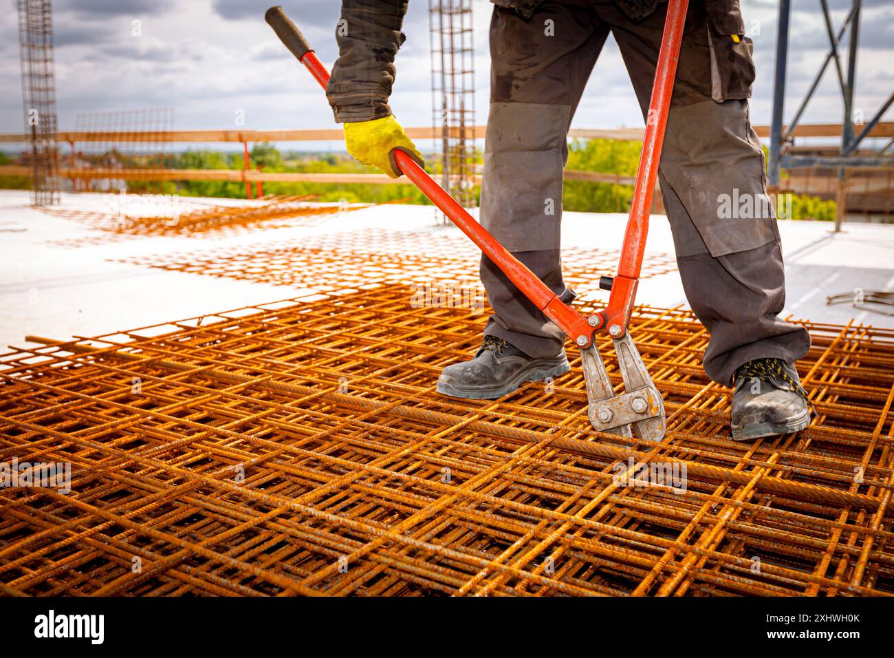 Worker is standing on pile of rusty rectangle steel, reinforcement for ...