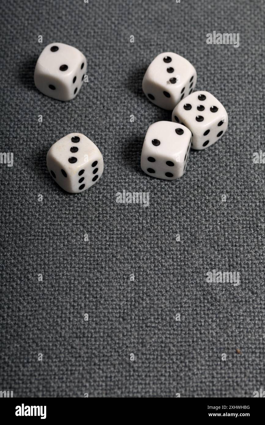 White dice with black markings. Lie on a surface covered with a coarse ...