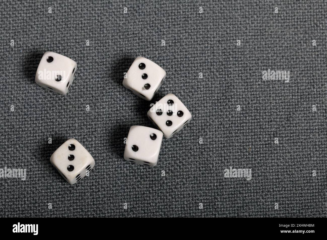 White dice with black markings. They lie on a surface covered with a ...