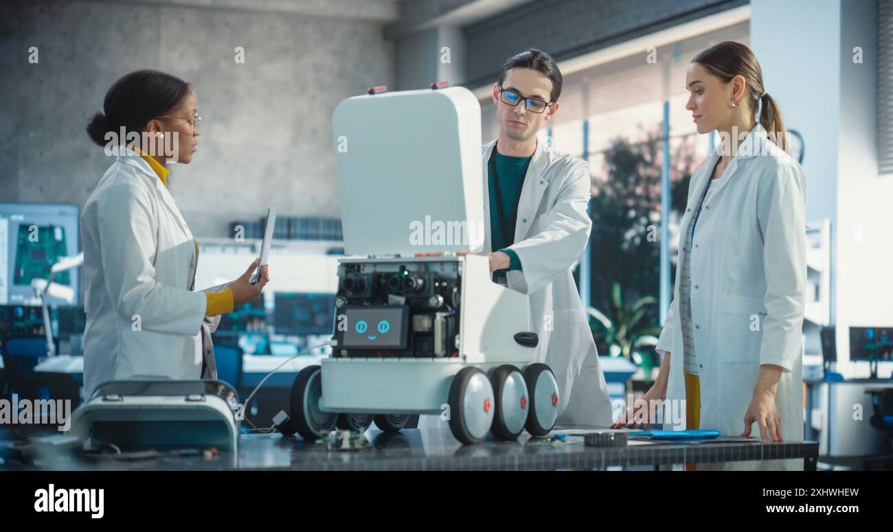 Team of Industrial Specialists Working on Mobile Robot, Using Laptop ...