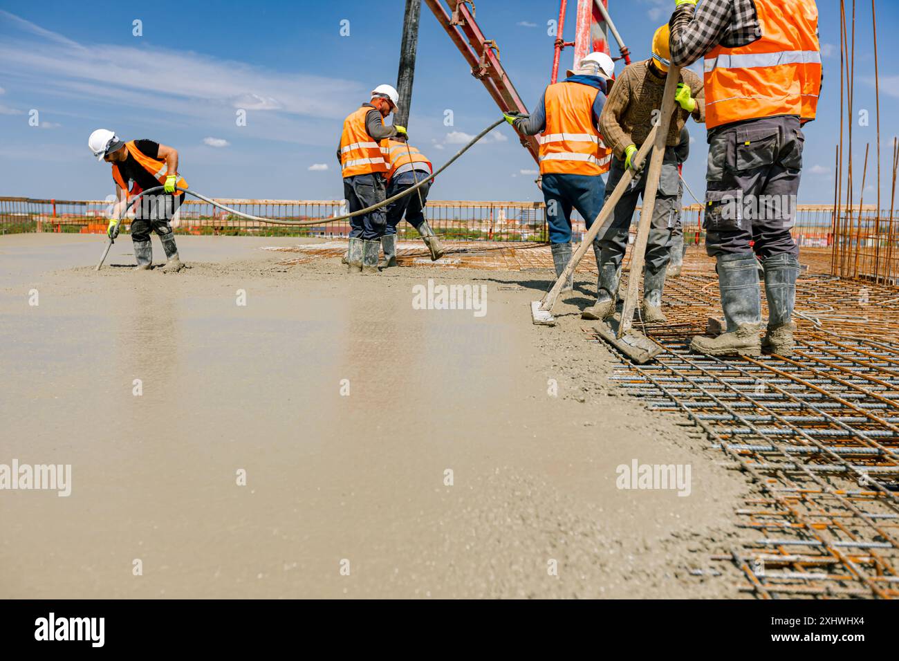 Team of construction workers are pouring and leveling fresh concrete ...