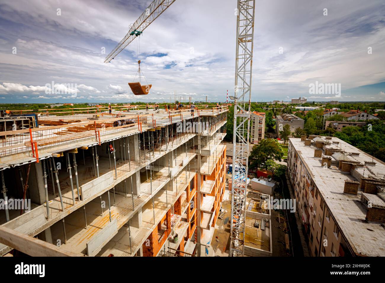 Tower crane is carry pile of rusty rectangle steel reinforcement for ...