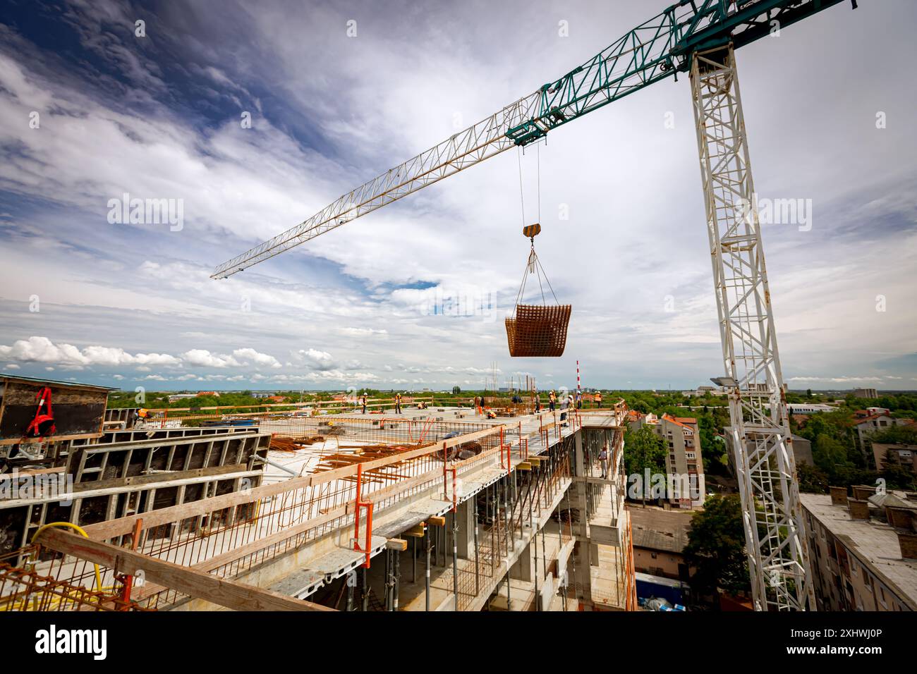 Tower crane is carry pile of rusty rectangle steel reinforcement for ...