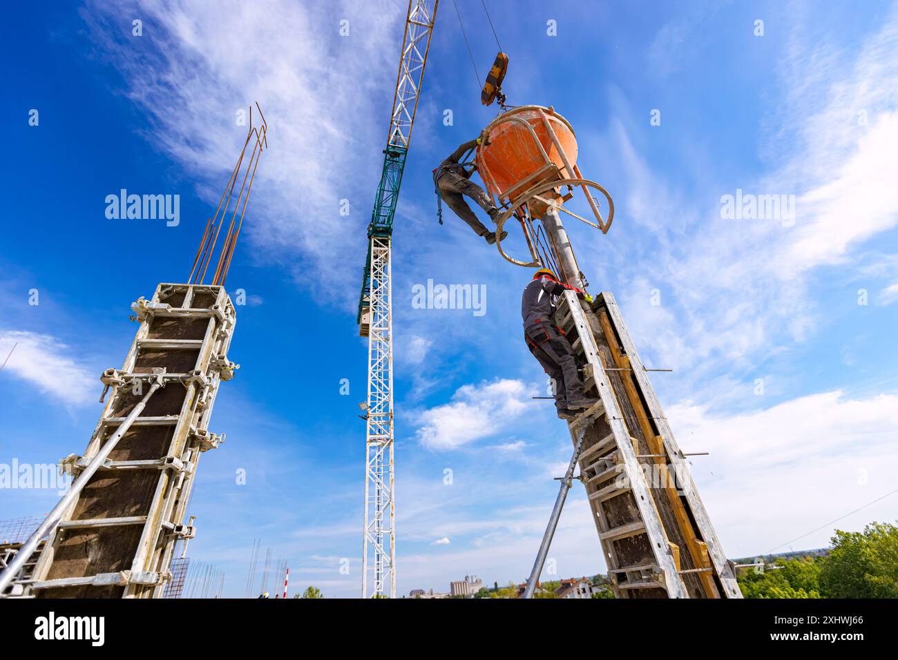 Construction workers are unloading conical metal bucket, transport and ...