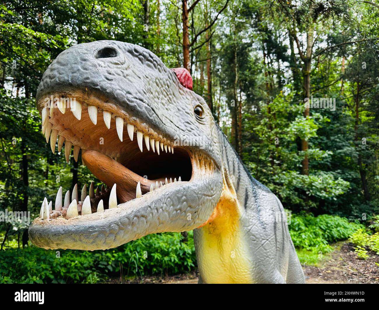 Realistic figure of an Allosaurus dinosaur inforest park in Kazimierz Sosnowiec. Prehistoric ...