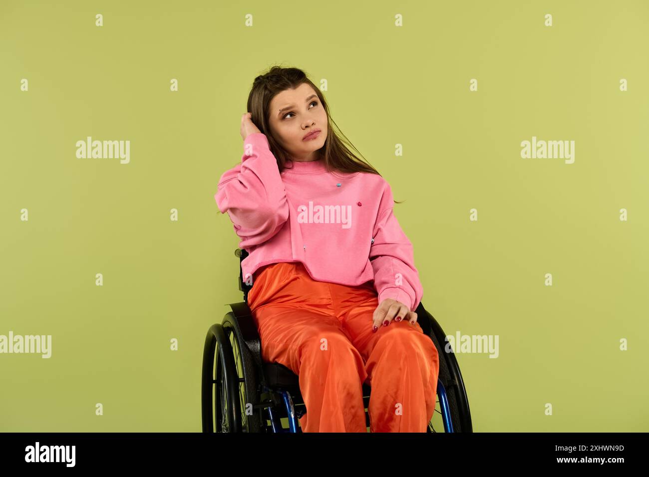 A contemplative brunette young woman with a disability, seated in a ...