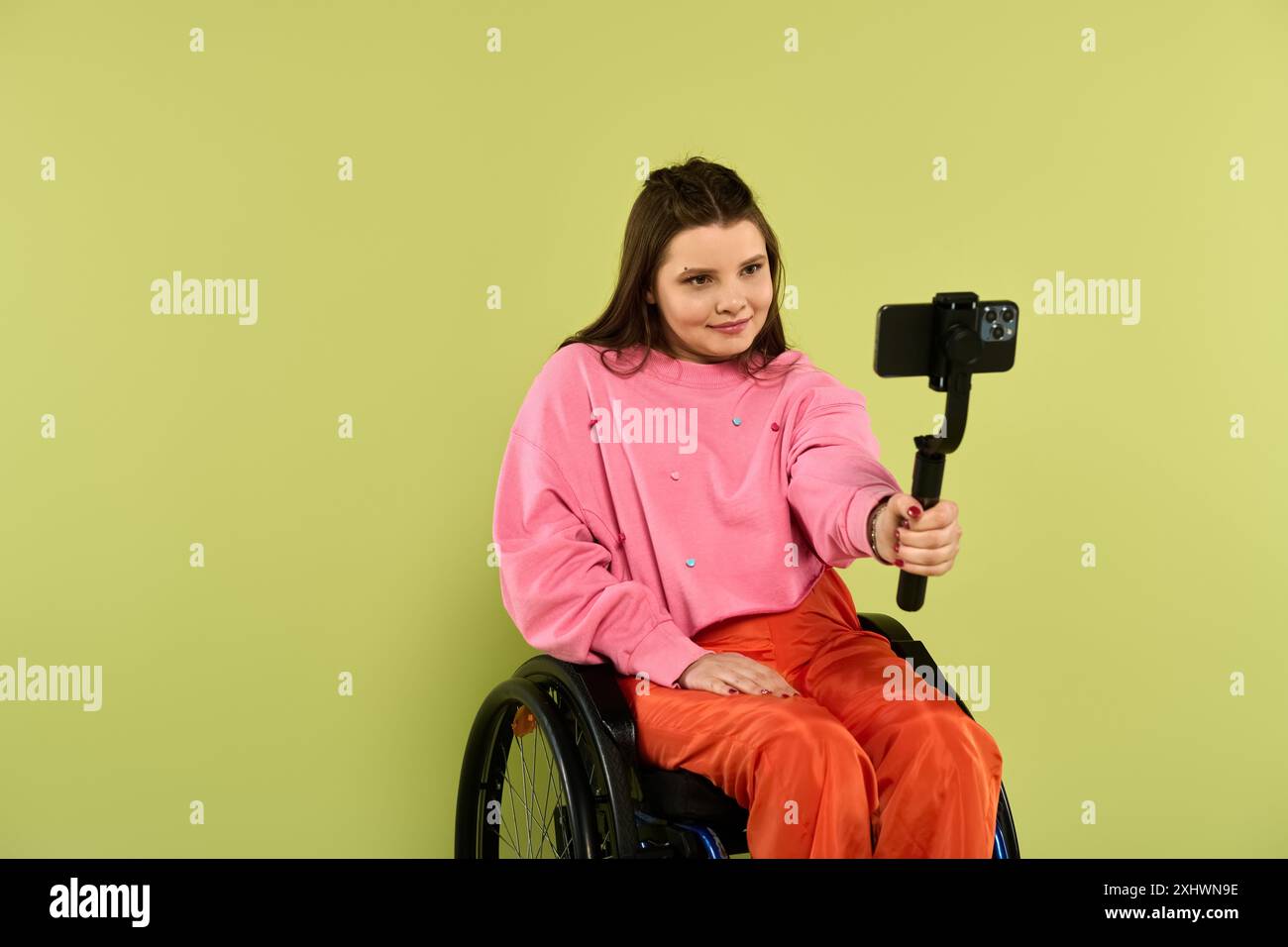 A young brunette woman with a disability is seated in a wheelchair in a ...