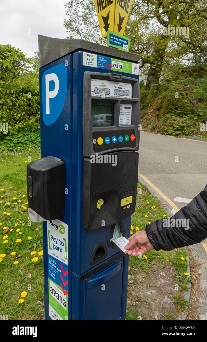 Man person buying ticket from parking meter at pay and display car park ...