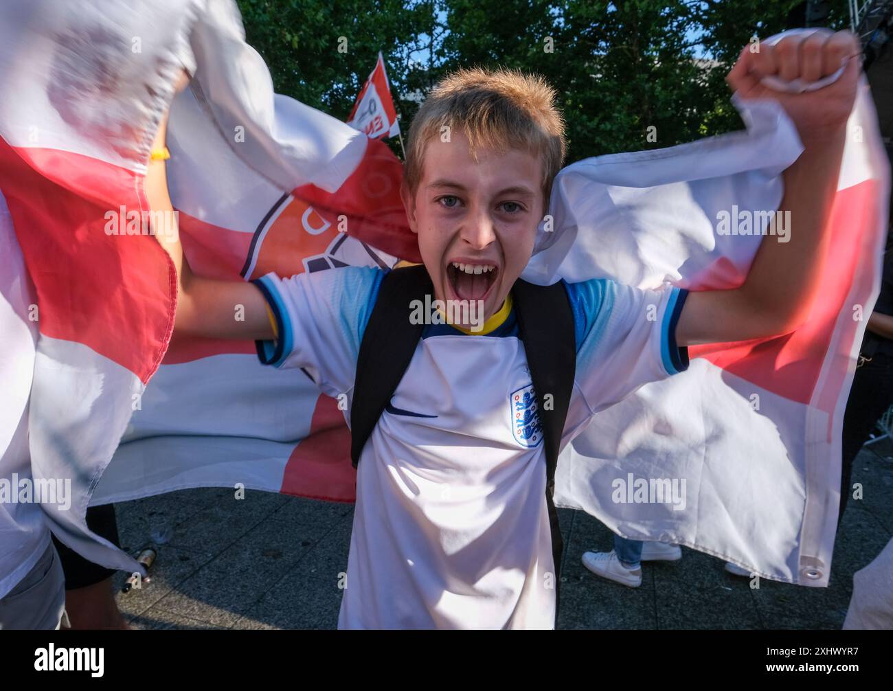 Young England football fan in Berlin draped in England flag cheering ...