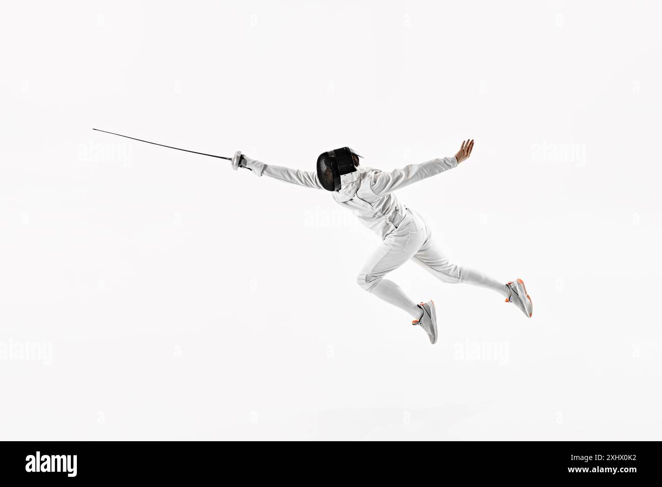 Fencer in mid-lunge, clad in white fencing suit and mask, with their ...