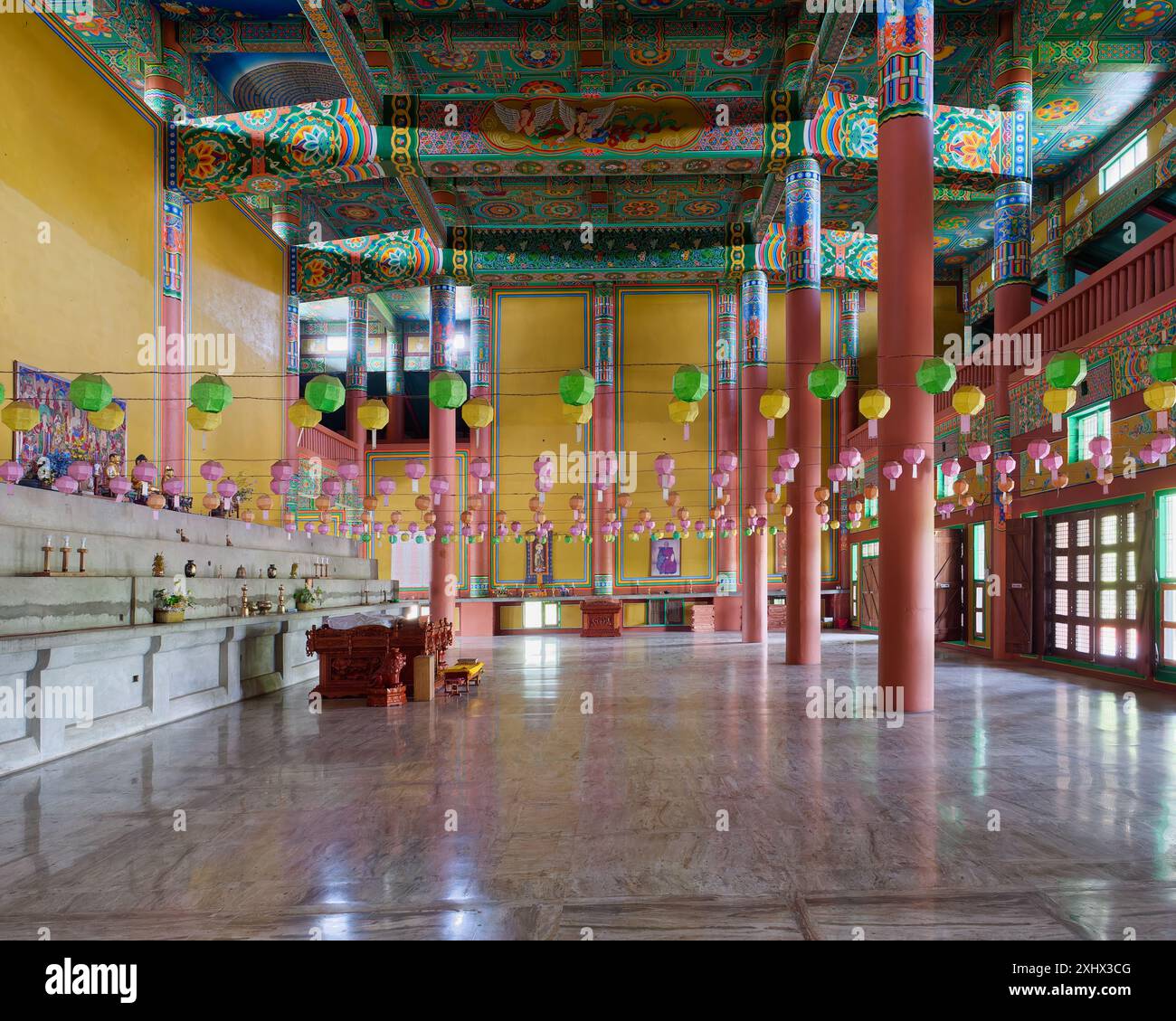 An interior of a colorful Buddhist temple with hanging lanterns and ...