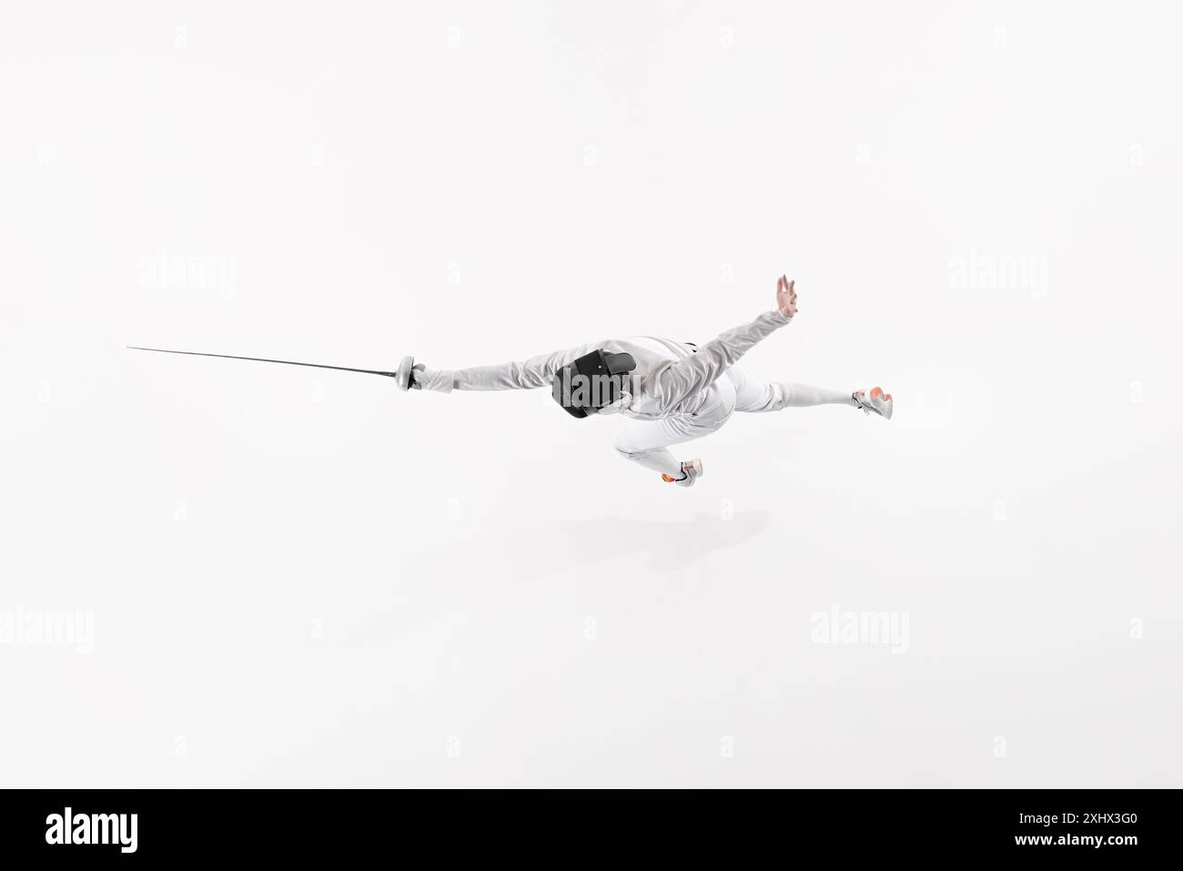 Fencer in white uniform and mask, captured from above in dramatic jump ...