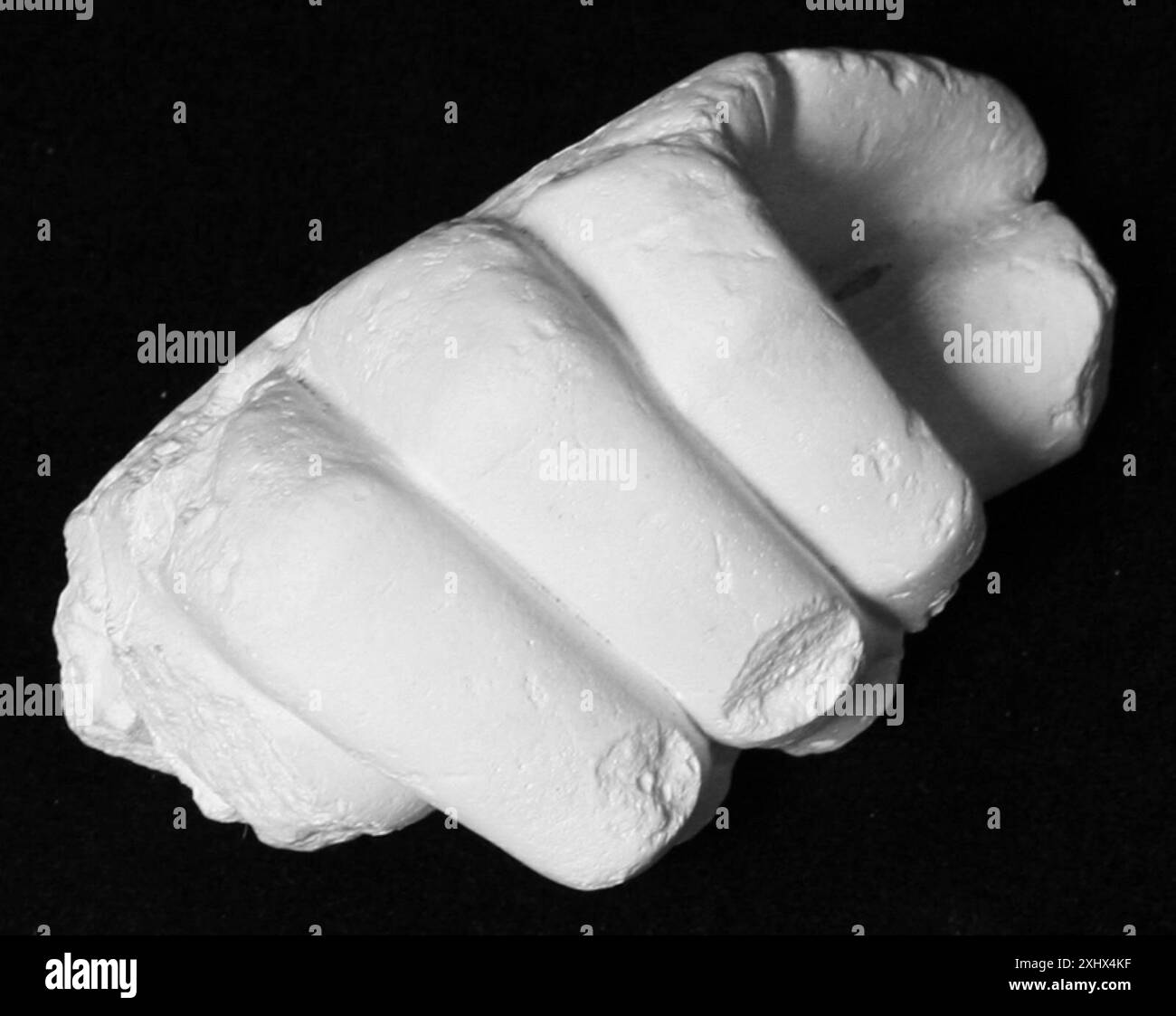 A statuette hand fragment gripping a round rod, showing three fingers ...