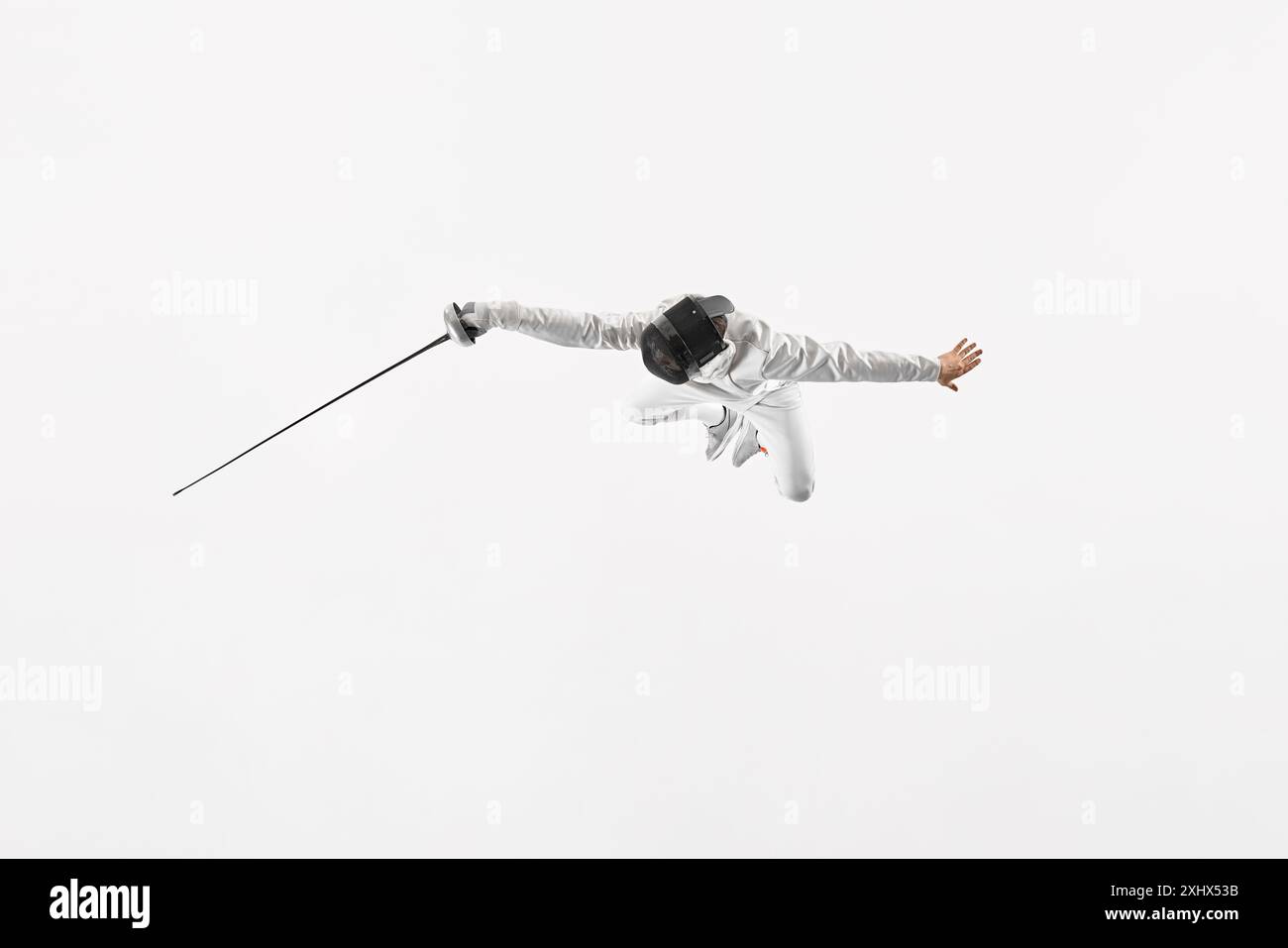 Young man, fencer in full gear lunges forward, poised to strike with ...