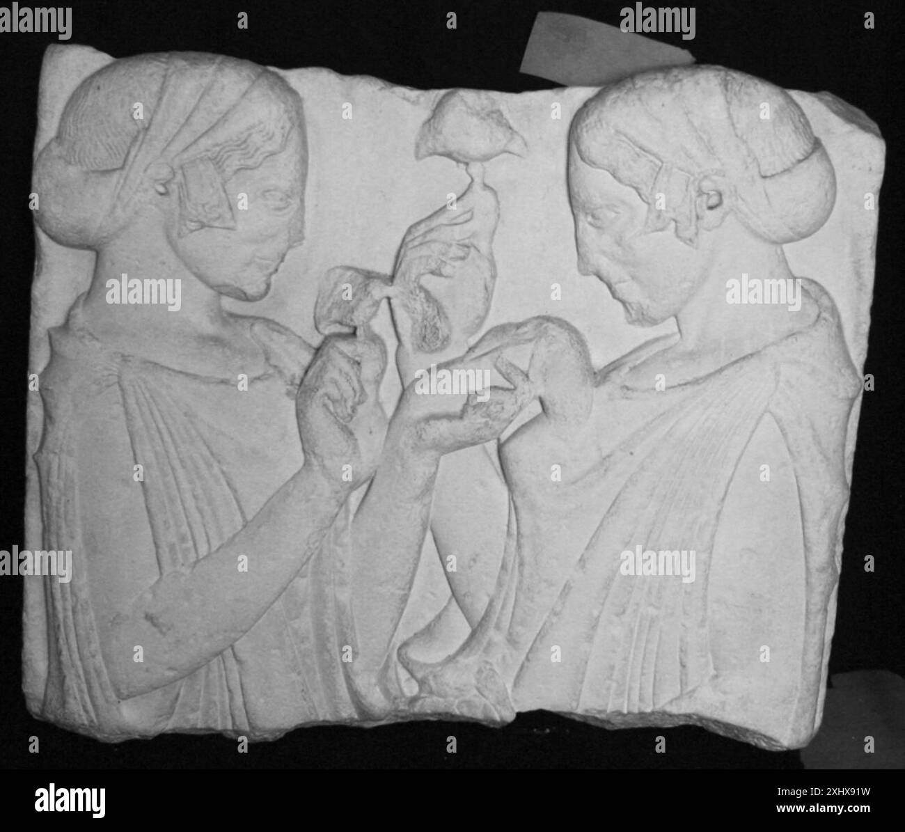 A grave relief showing two women in profile facing each other, holding ...