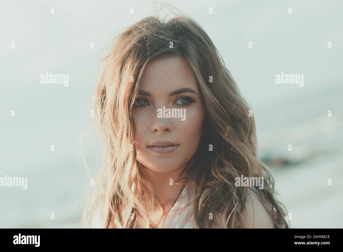 Stylish young adult female model with windy brown hair walking outdoor ...