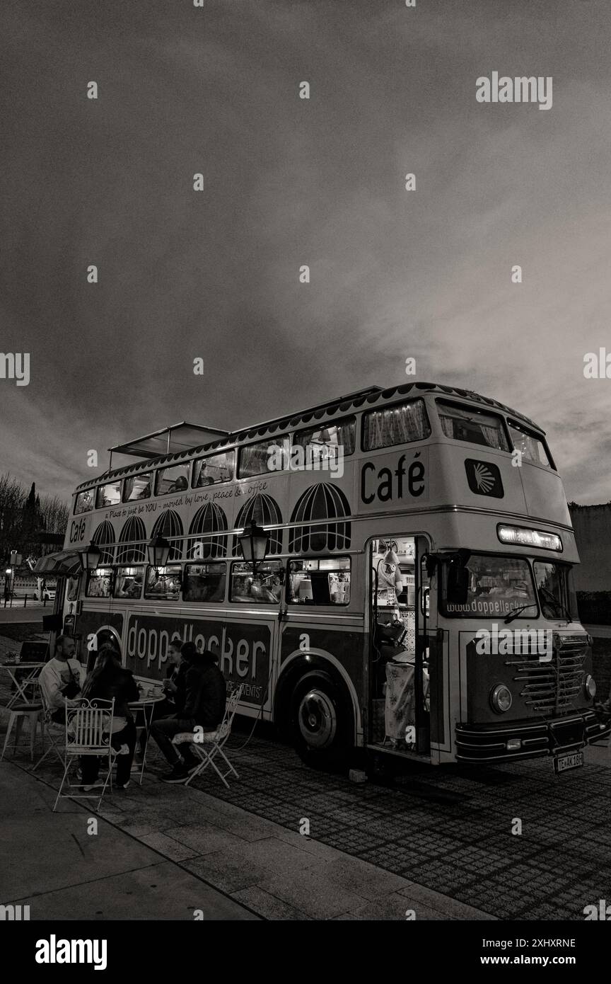 Monochrome of a double-decker bus cafe filled with people in Batalha ...