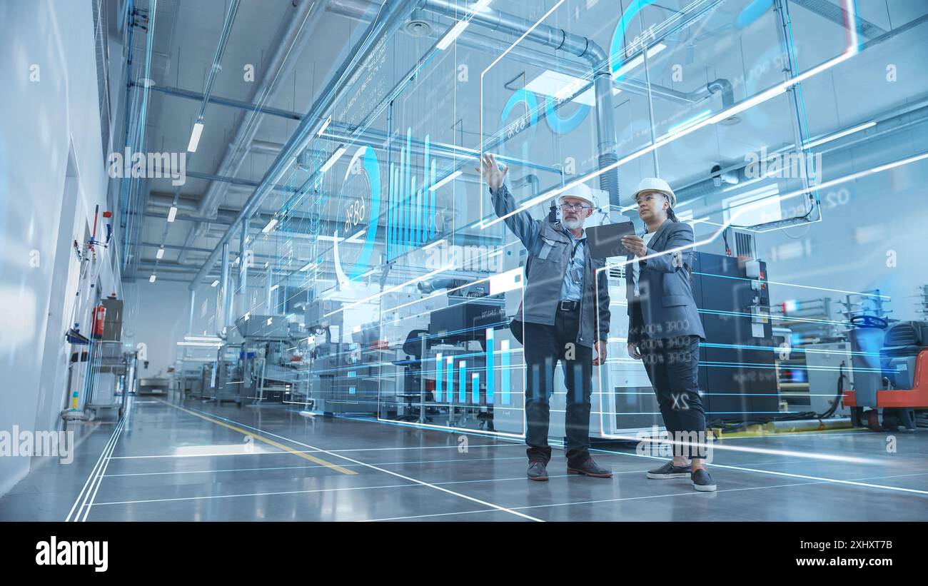 Factory Digitalization: Two Industrial Engineers Use Tablet Computer, Visualize the Wall of Big ...