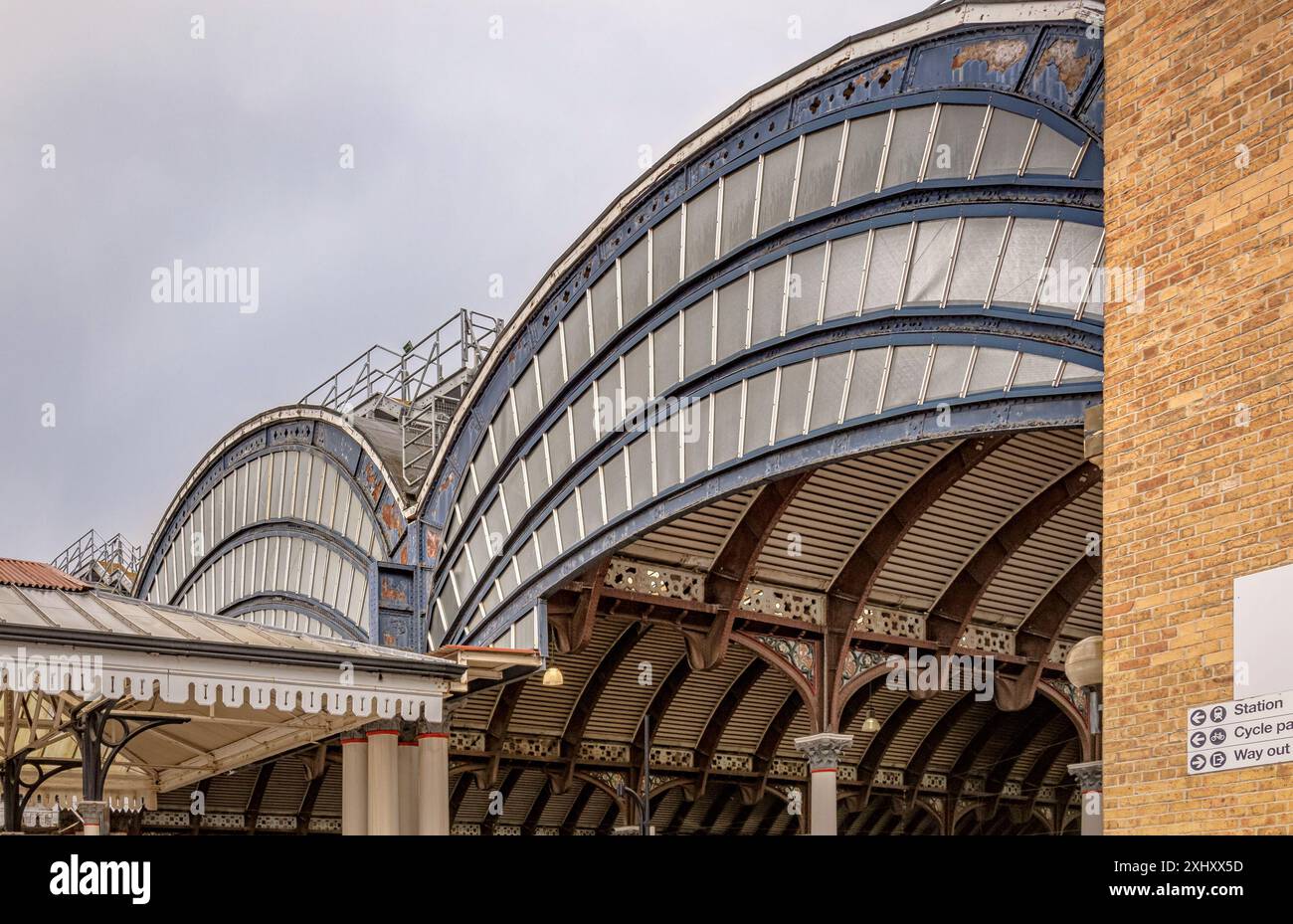 Two old large arches of iron and glass form the entrance to a railway ...