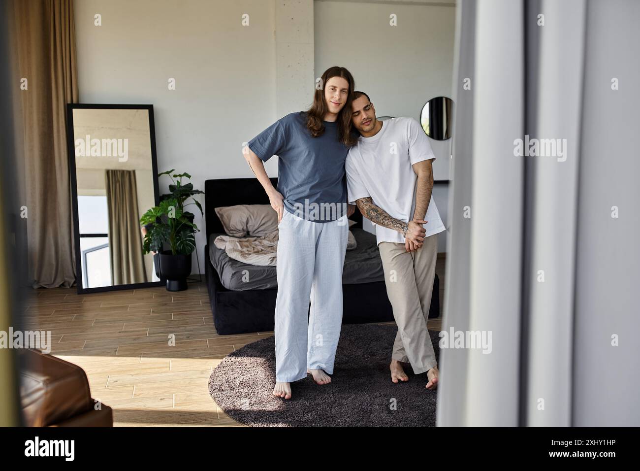 Two young men stand close together in a bedroom, showcasing their love ...