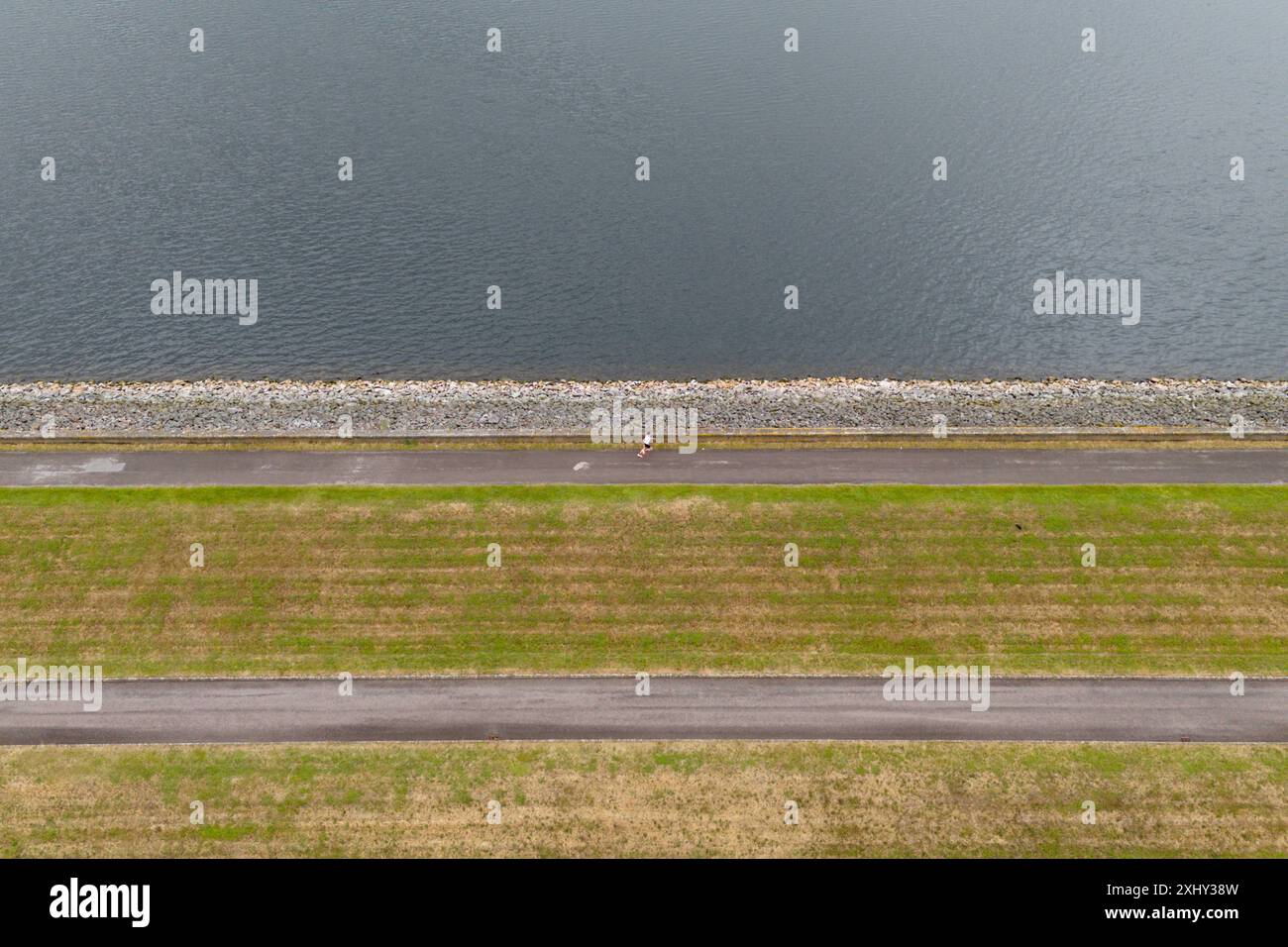 A runner passes a reservoir at Draycote Water in Rugby, Warwickshire ...