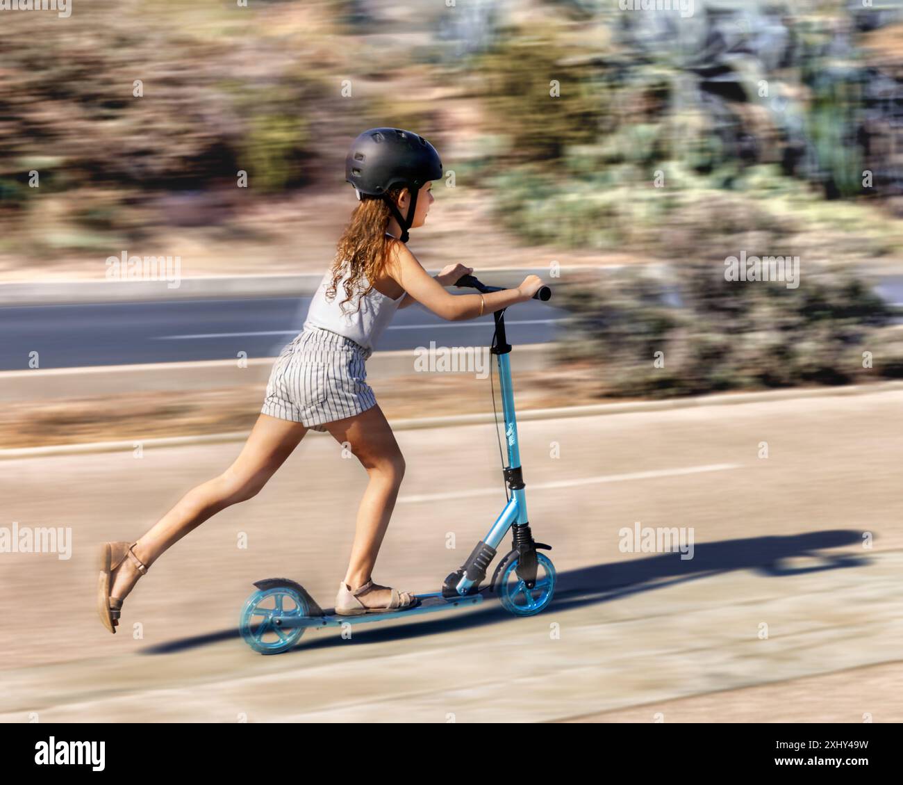 FRANCE. OCCITANY. HERAULT (34) SETE. LITTLE GIRL HELMETED ON A SCOOTER ...