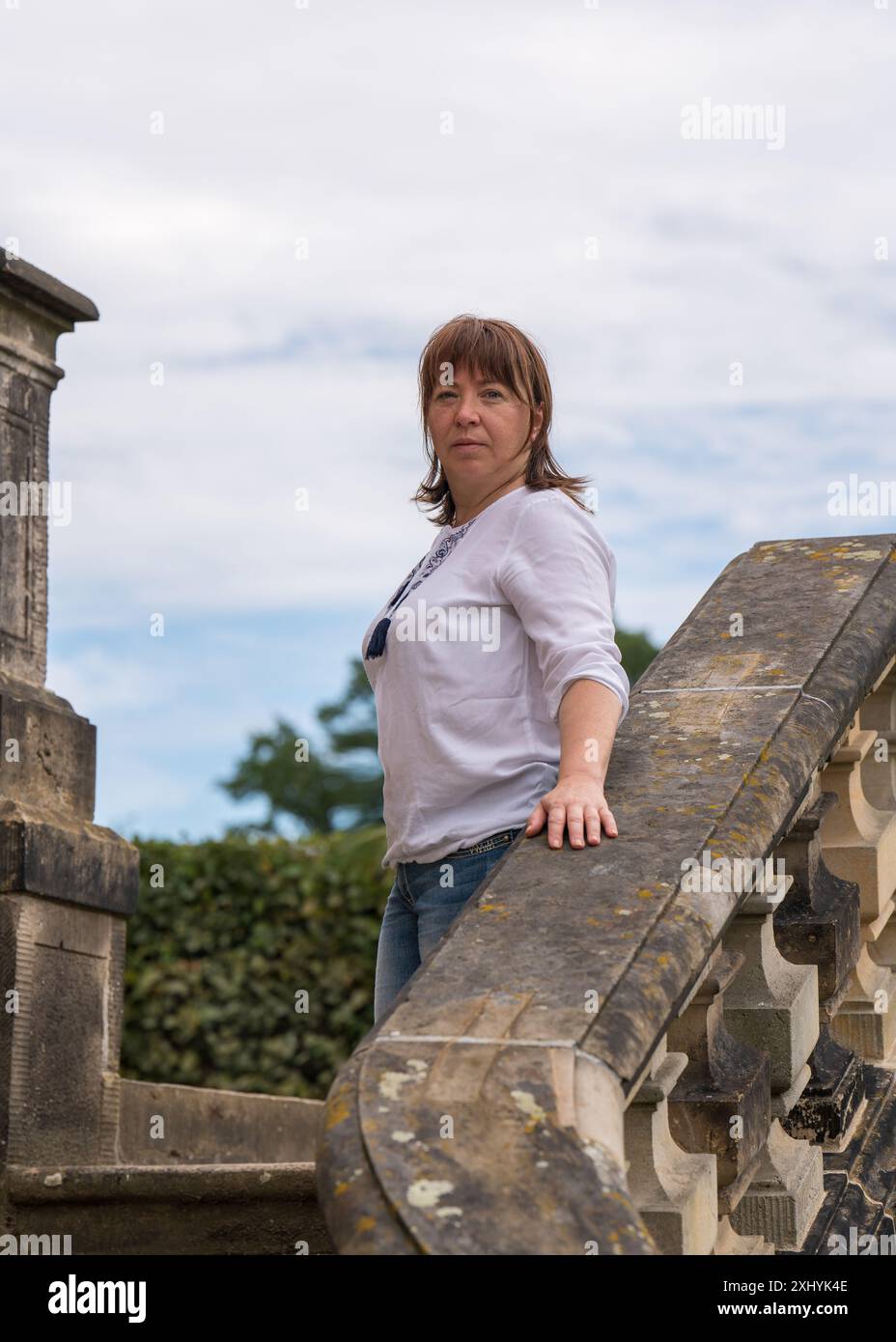 Happy female traveler visiting new places stands on the steps of the ...