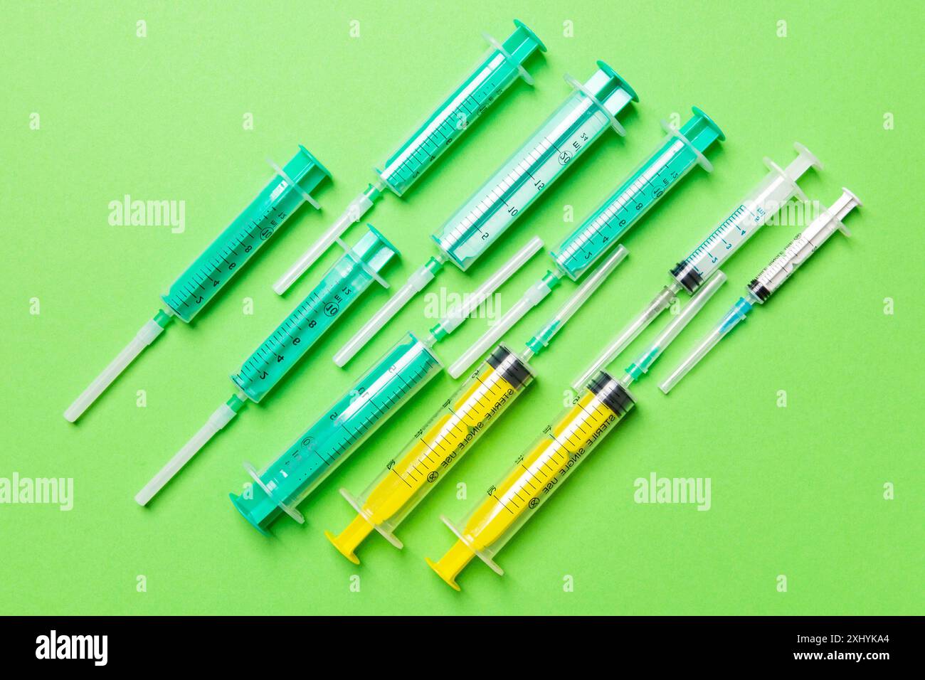 Top view of medical syringes with needles at green background with copy ...