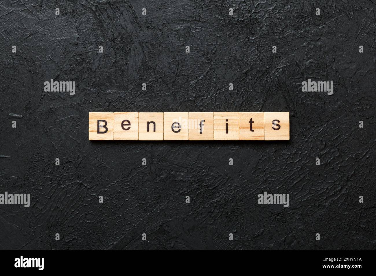 Benefits word written on wood block. Benefits text on cement table for ...