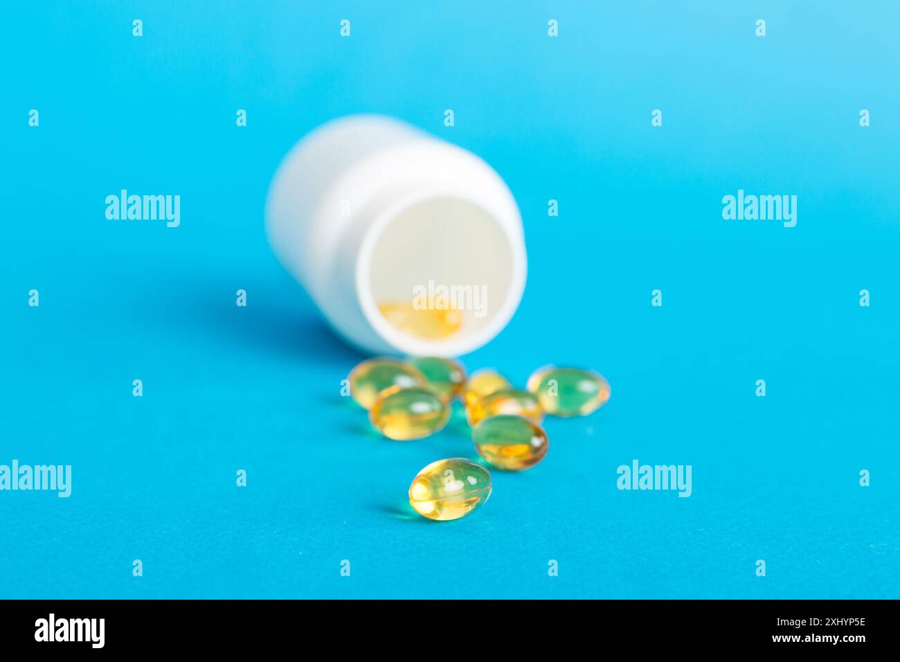 Soft gels pills with Omega-3 oil spilling out of pill bottle close-up ...