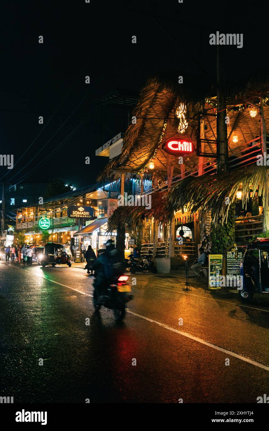 Night scene of a vibrant street with colorful neon lights and people ...