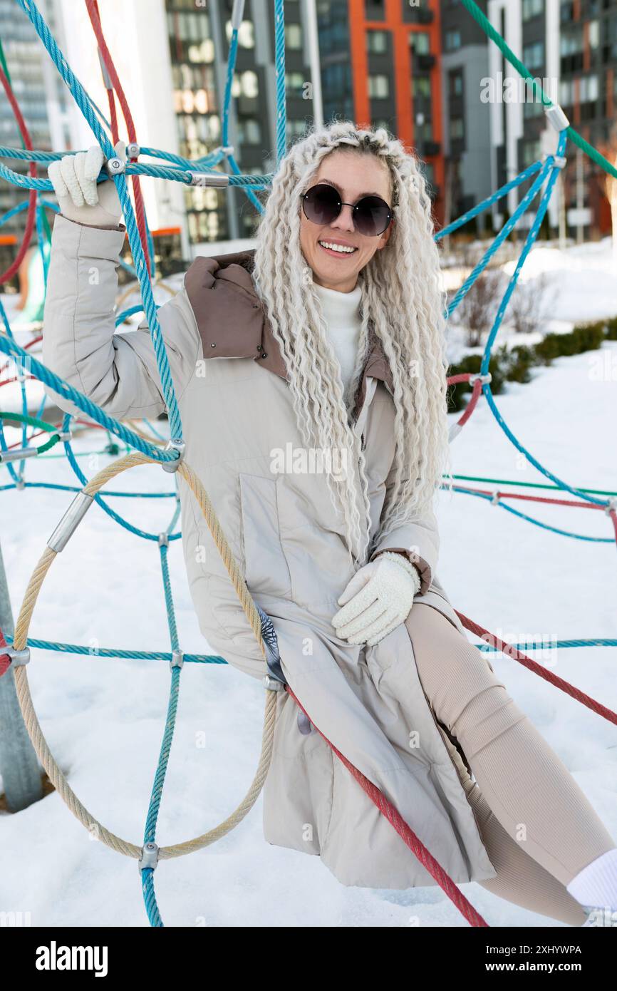 A woman is seen sitting on a rope set up in the snow-covered ground ...
